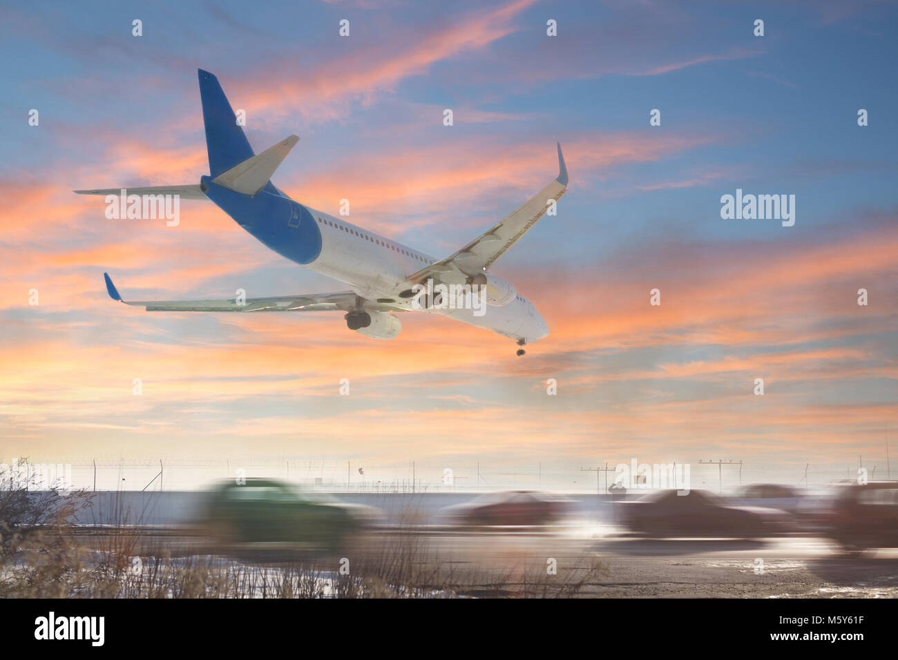 Tail view of landing airplane. Aircraft flying over highway. Road with ...