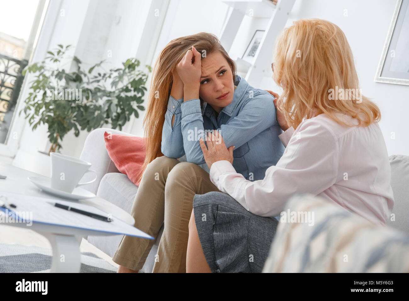 Female psychologyst therapy session with client indoors sitting girl ...