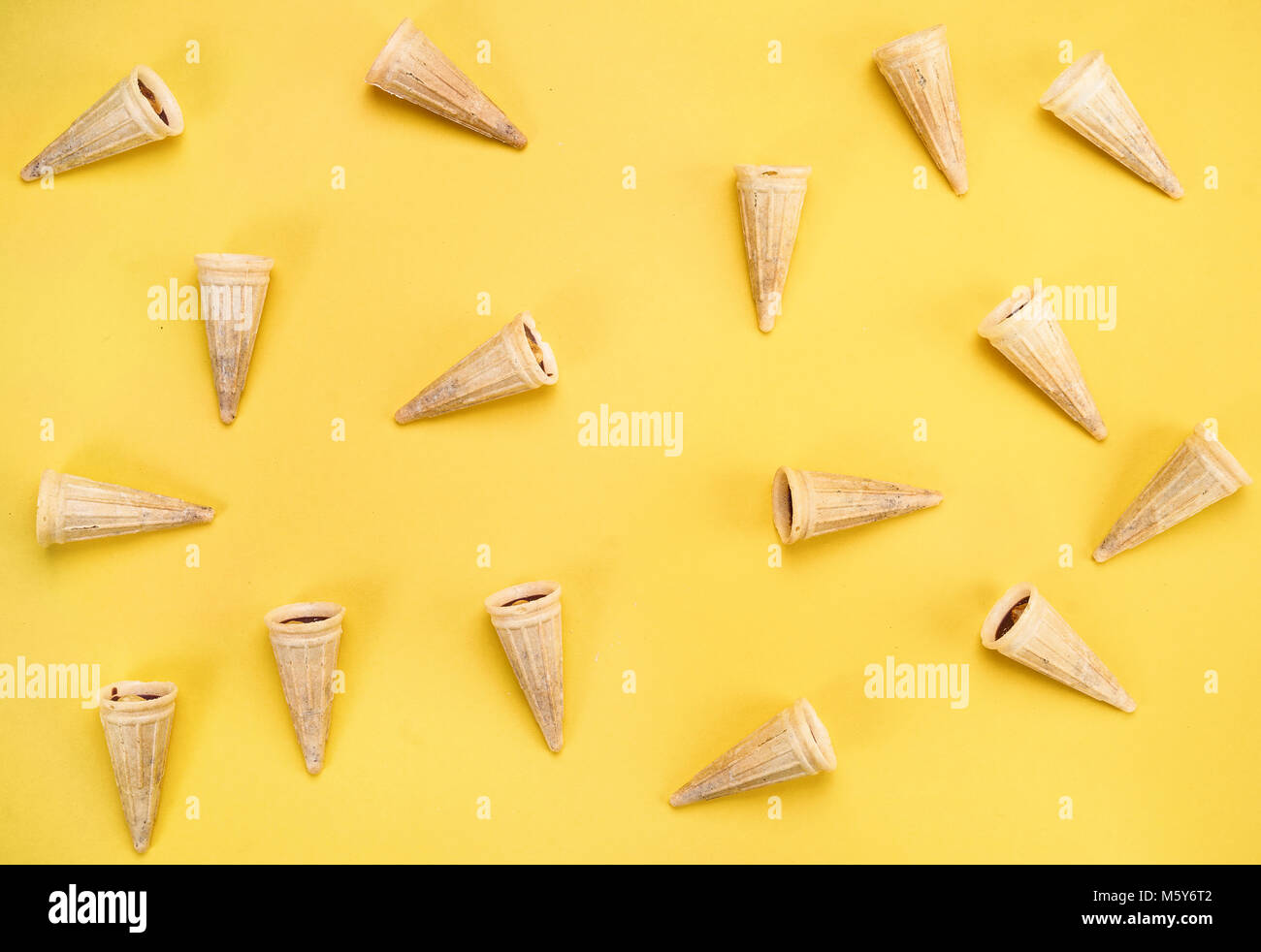 Top view of mini waffle cones on yellow background Stock Photo - Alamy