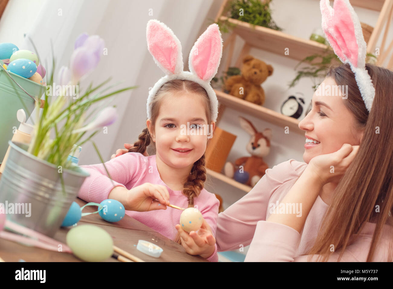 Mother and daughter together easter preparation at home sitting in ...