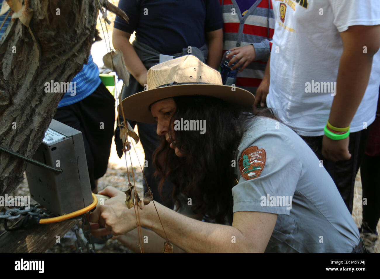Checking a camera trap. Ranger Joanne shows students a camera trap ...