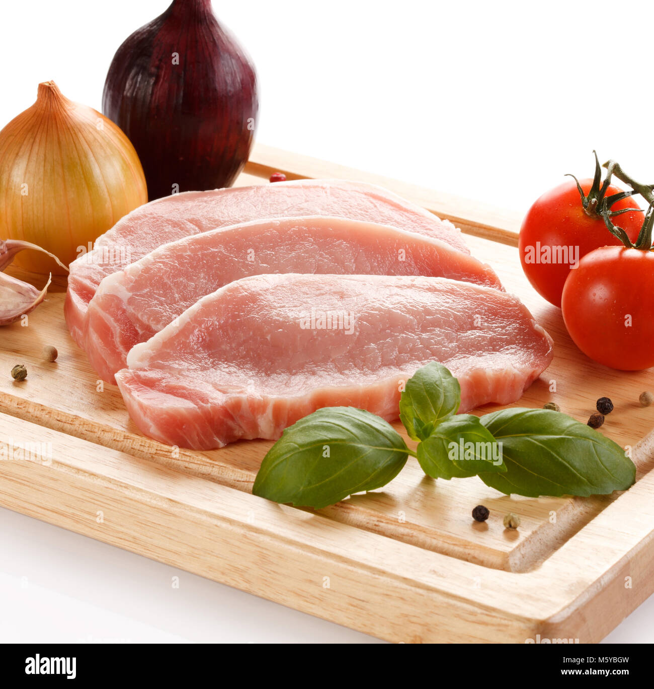 Raw pork chops on cutting board and vegetables Stock Photo - Alamy