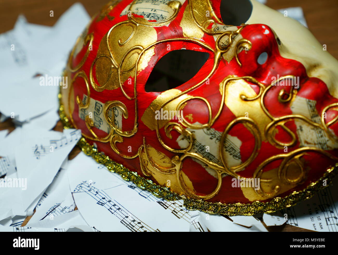 Music notes on golden and red carnival mask and teared paper music ...