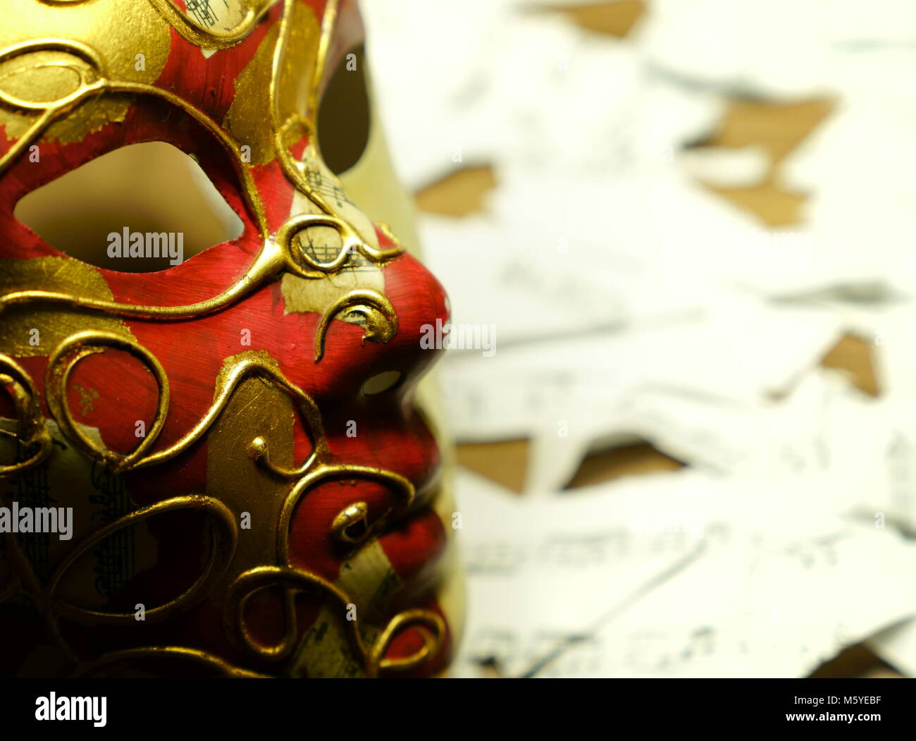 Music notes on golden and red carnival mask and teared paper music ...
