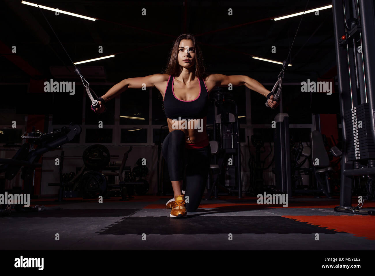 Athlete girl in sportswear working out and training her arms and ...