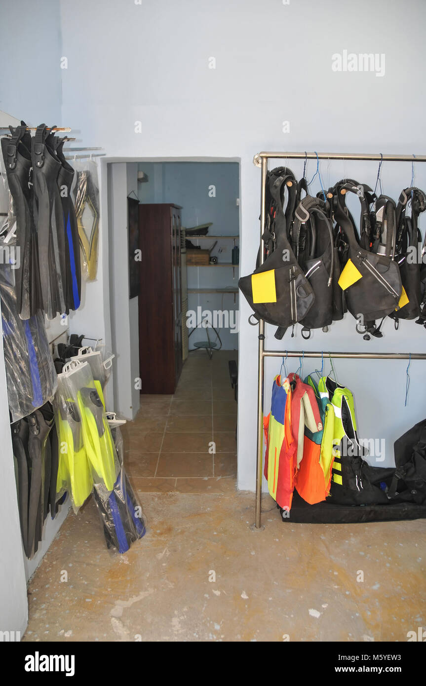 Diving gear hanging on racks including flippers, buoyancy compensation ...