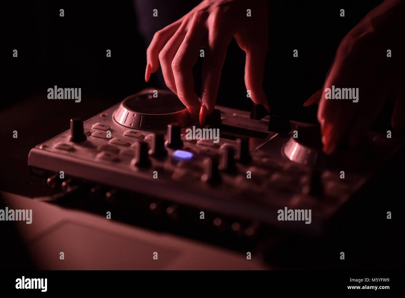 DJ mixer disco illuminated by searchlights Stock Photo - Alamy