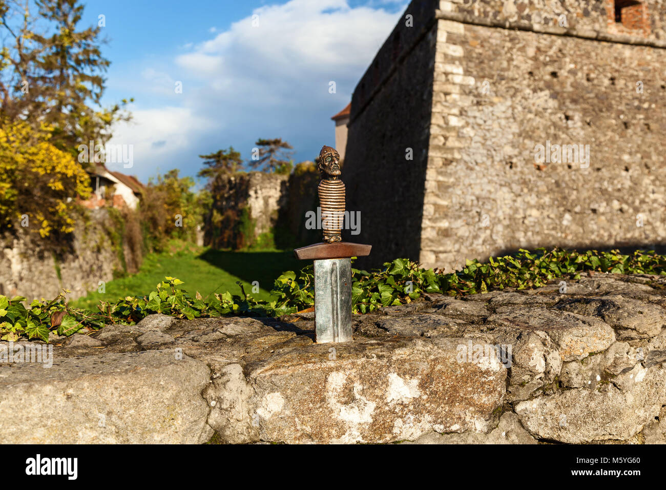 Sword in stone. Sword of King Arthur in stone. Steel blade weapon of ...