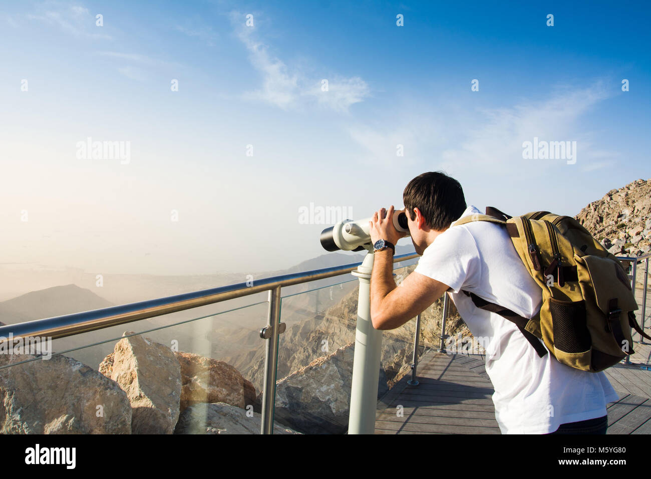 Man looking at the mountain range view from public binoculars Stock ...