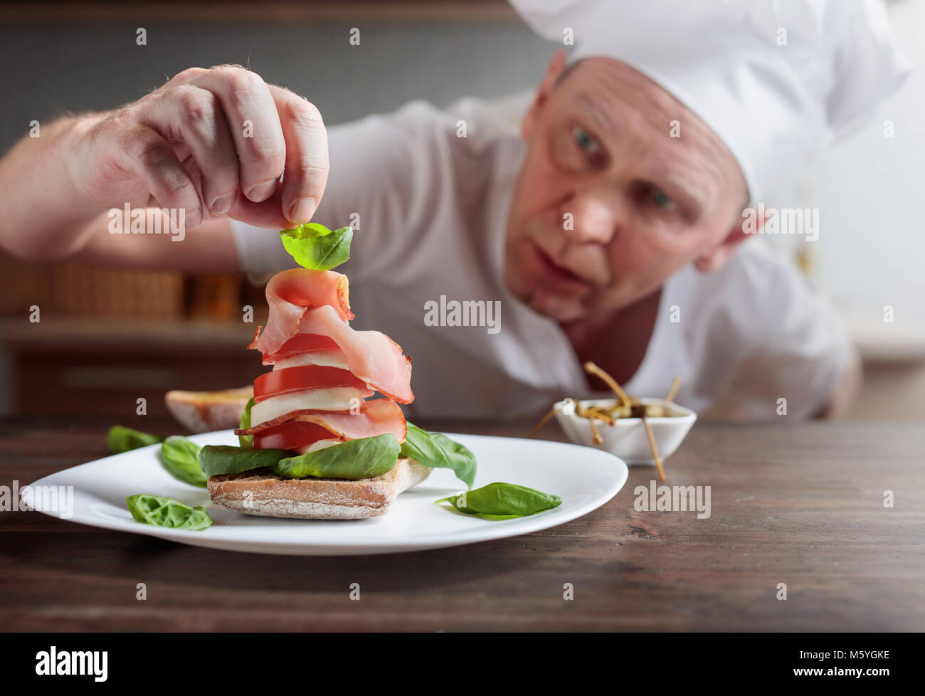 Chef prepares a snack with mozzarella and smoked meat . Selective focus ...