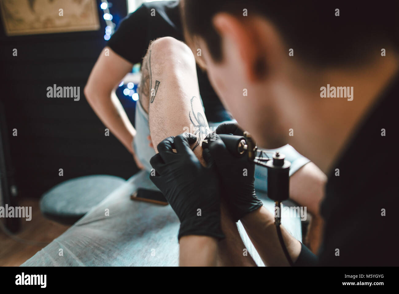 Professional tattoo artist makes tattoo Stock Photo - Alamy