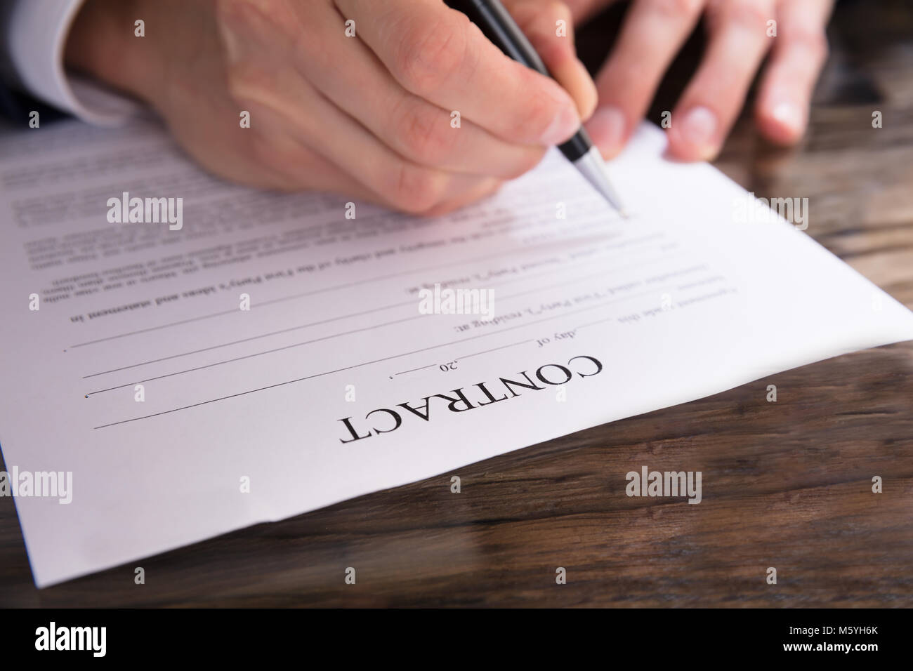 Close-up Of A Businessperson's Hand Filling Contract Form Stock Photo ...