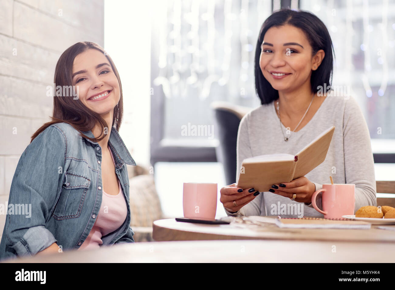 Happy two friends discussing agenda Stock Photo - Alamy