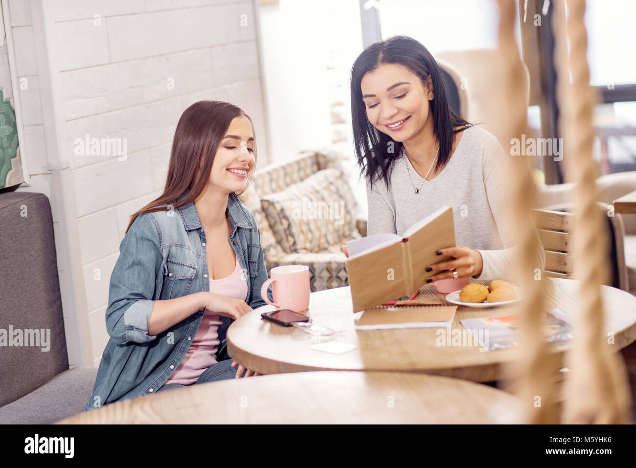 Optimistic two friends planning weekends Stock Photo - Alamy
