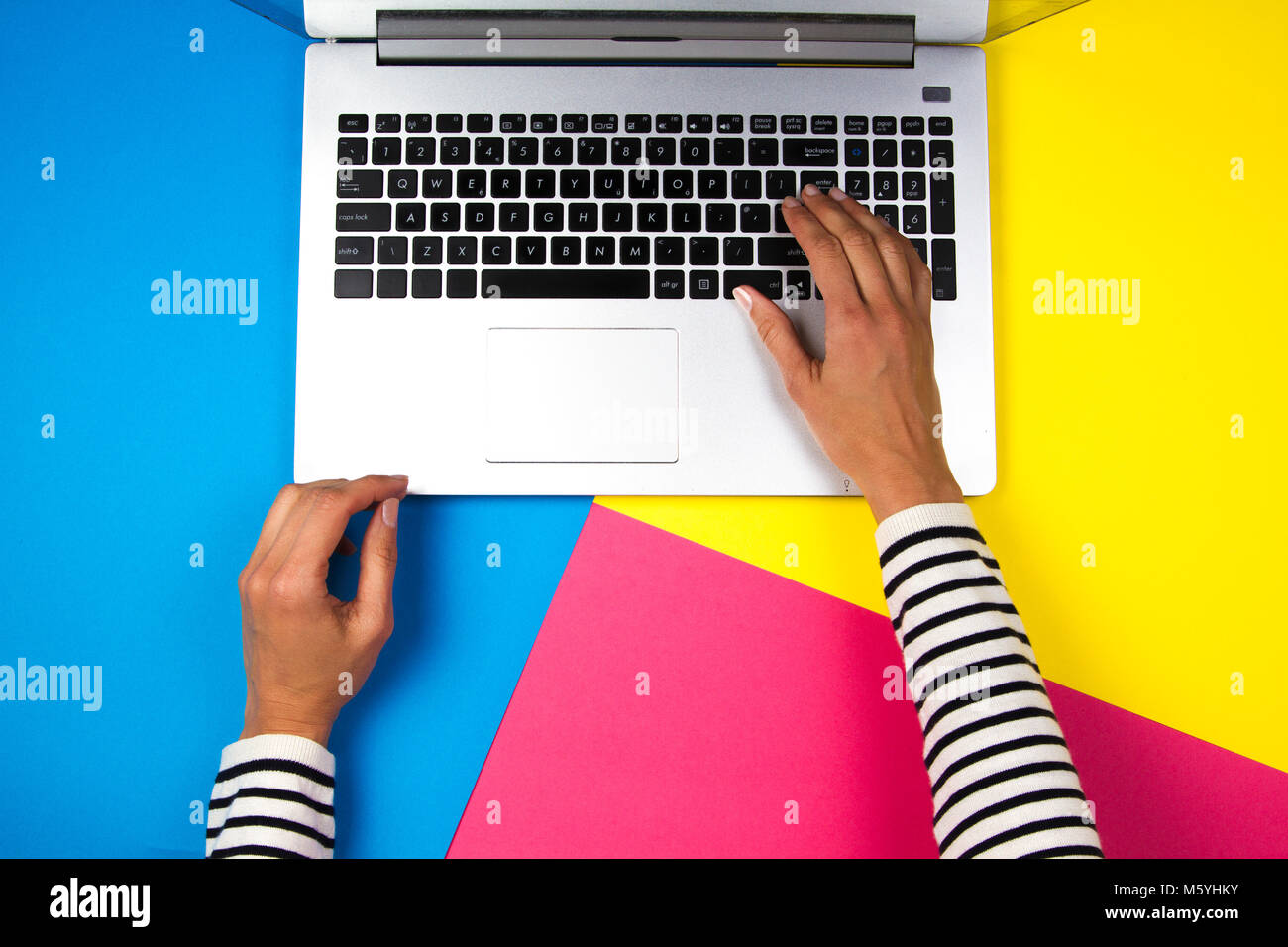 Woman hands using laptop on colorful background Stock Photo - Alamy