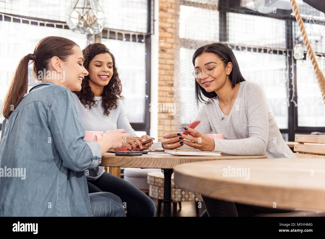 Jovial three friends watching video Stock Photo - Alamy