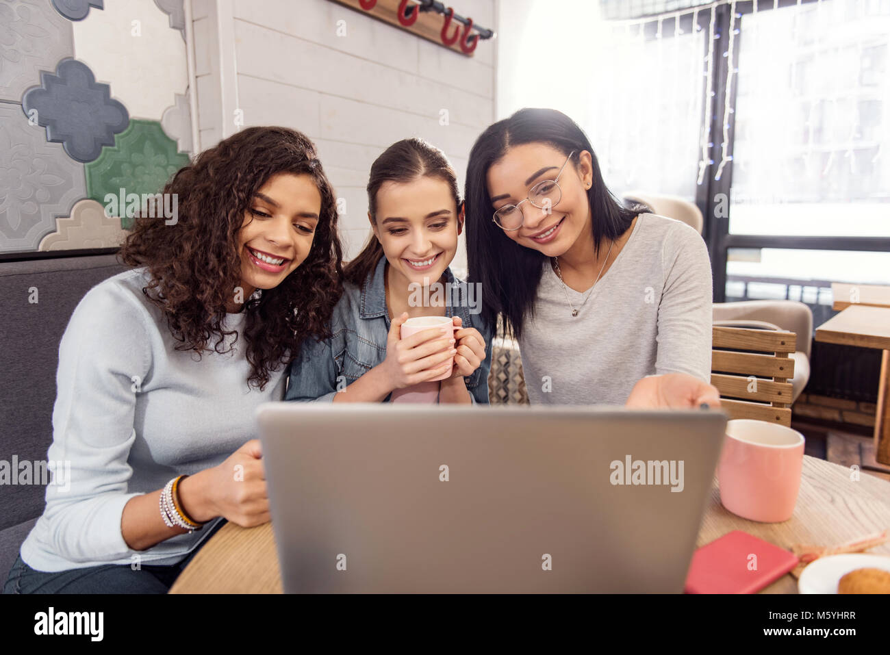 Cheerful three students finishing their work Stock Photo - Alamy