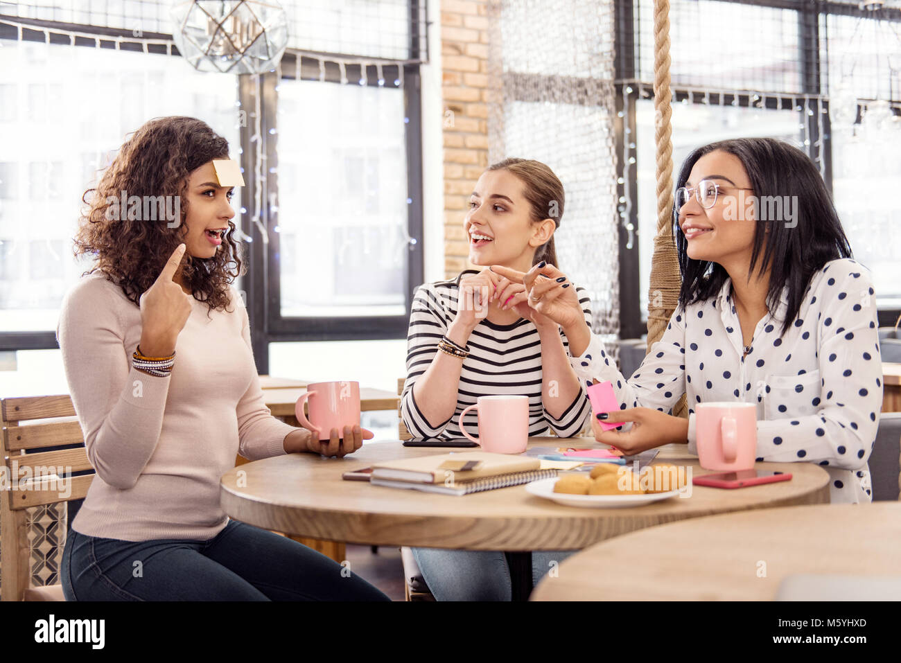 Relaxed three friends guessing personage Stock Photo - Alamy