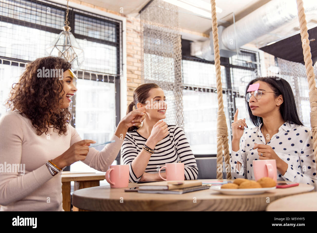 Happy three friends guessing character Stock Photo - Alamy