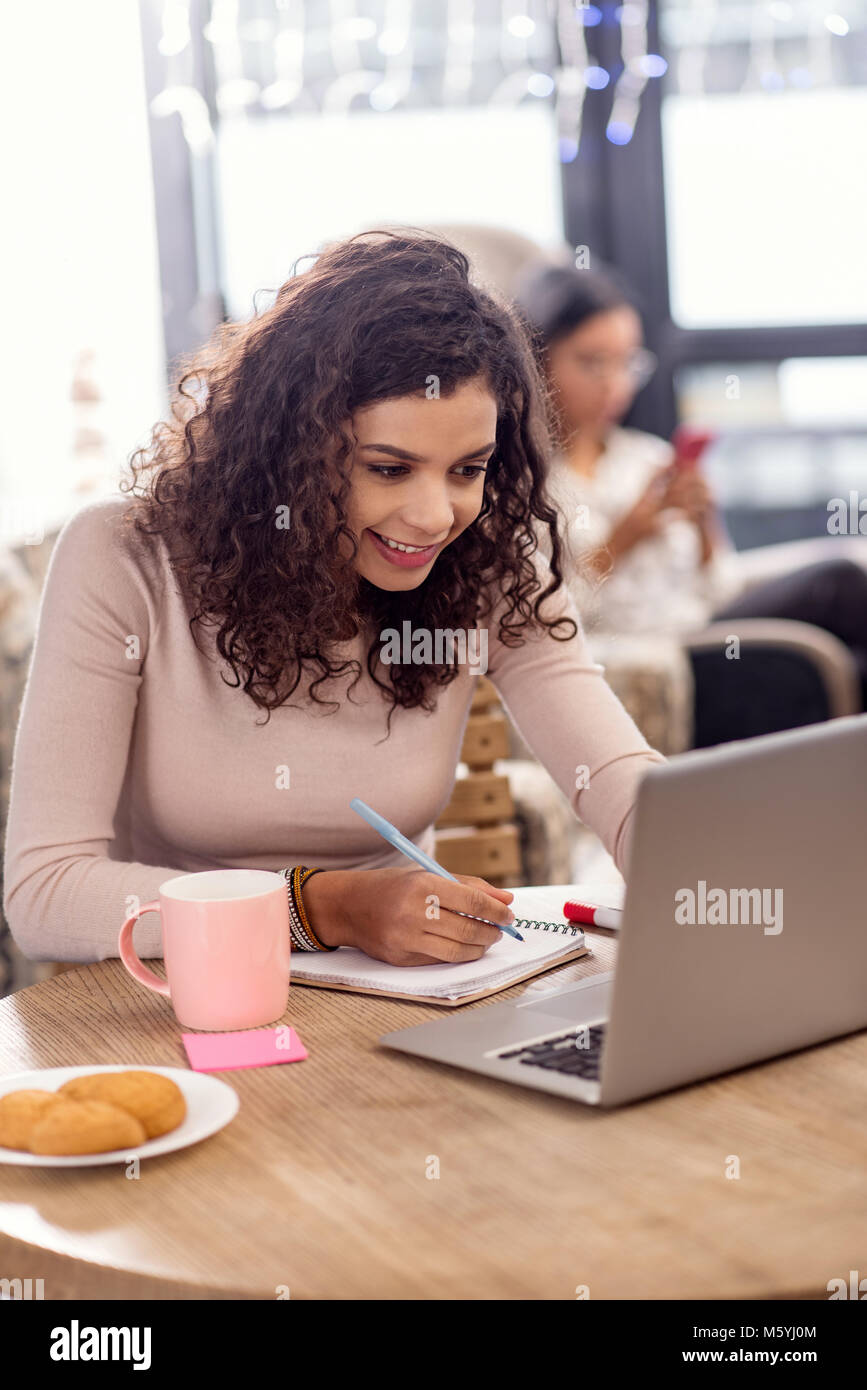 Optimistic female freelancer searching project Stock Photo - Alamy