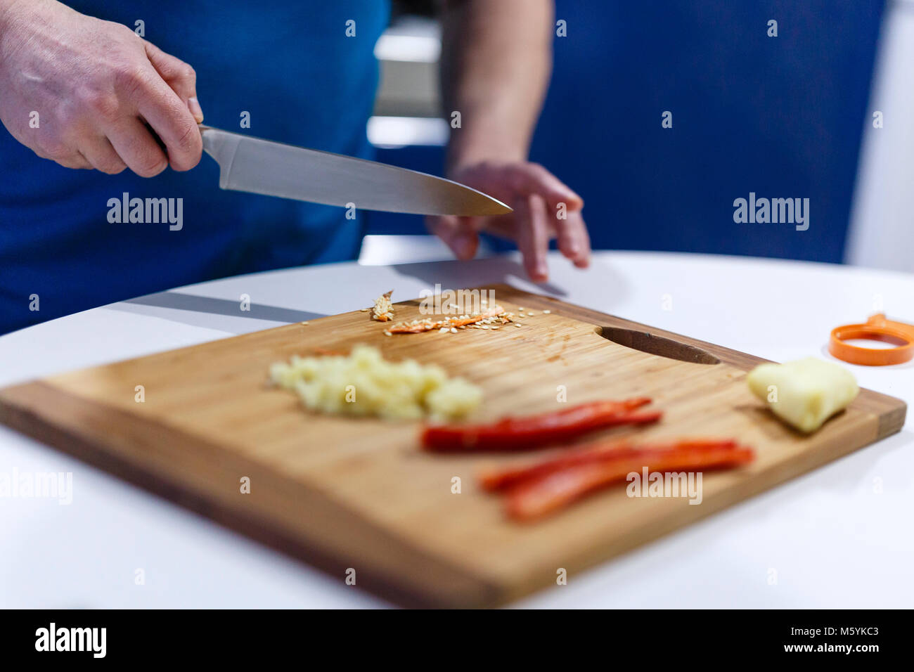 man cuts vegetables on a wooden lumber in the kitchen Stock Photo - Alamy