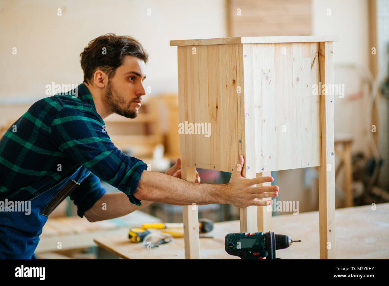 carpenter testing wood plank evenness at workshop Stock Photo - Alamy