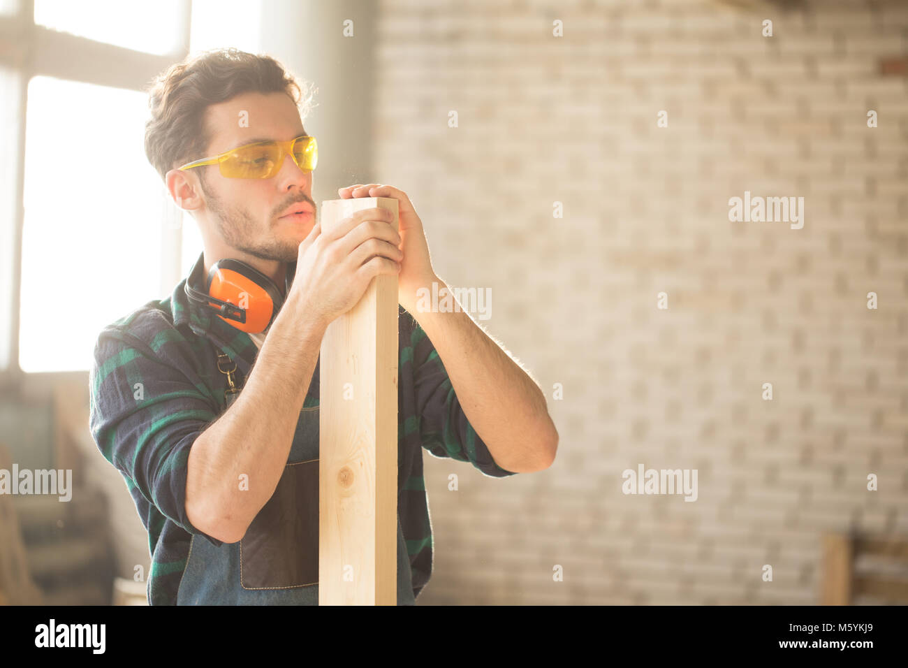 carpenter testing wood plank evenness at workshop Stock Photo - Alamy