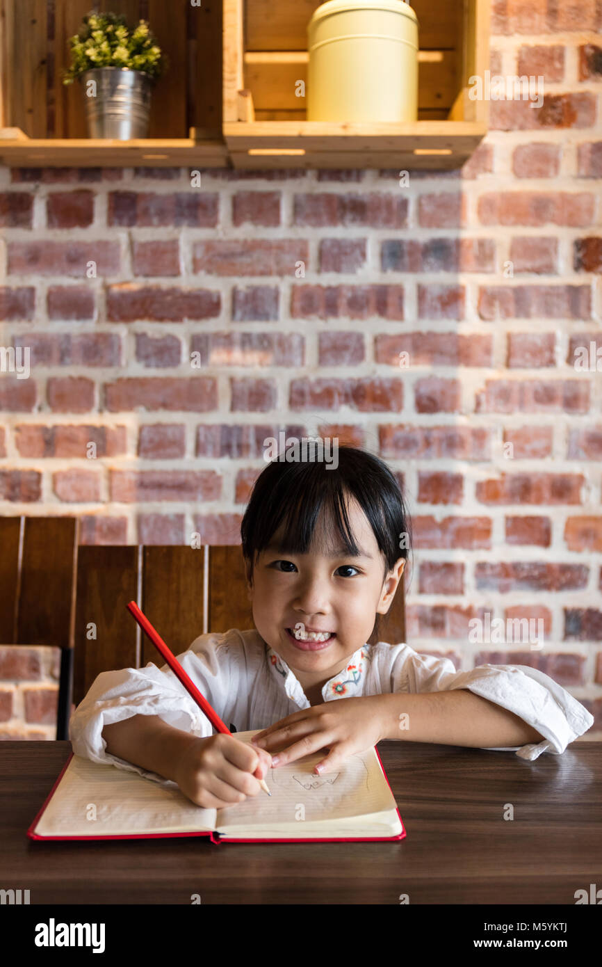 Asian Chinese little girl doing homework at indoor cafe Stock Photo - Alamy