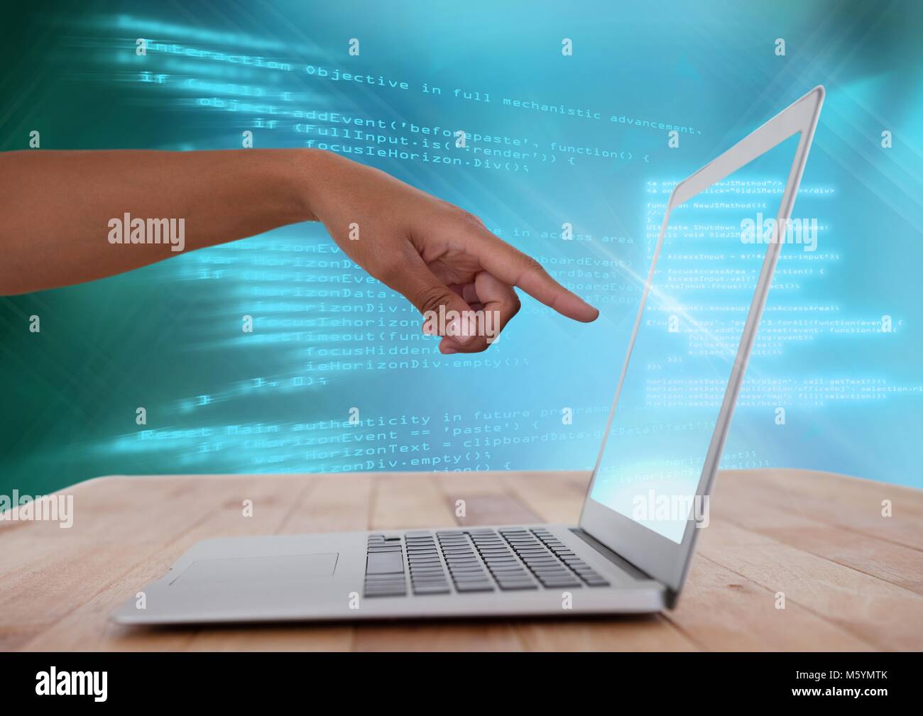 Hand pointing at laptop with coding text Stock Photo - Alamy