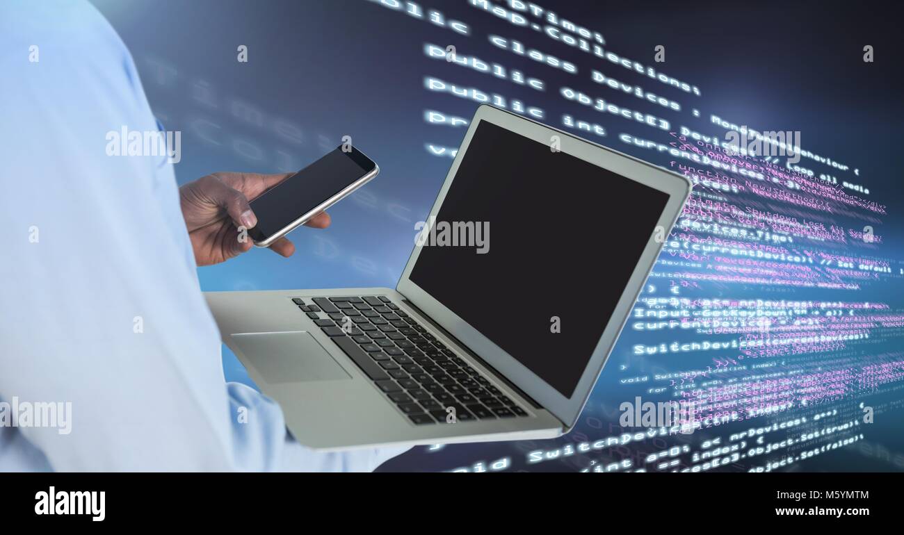 Holding phone and laptop with coding text Stock Photo - Alamy