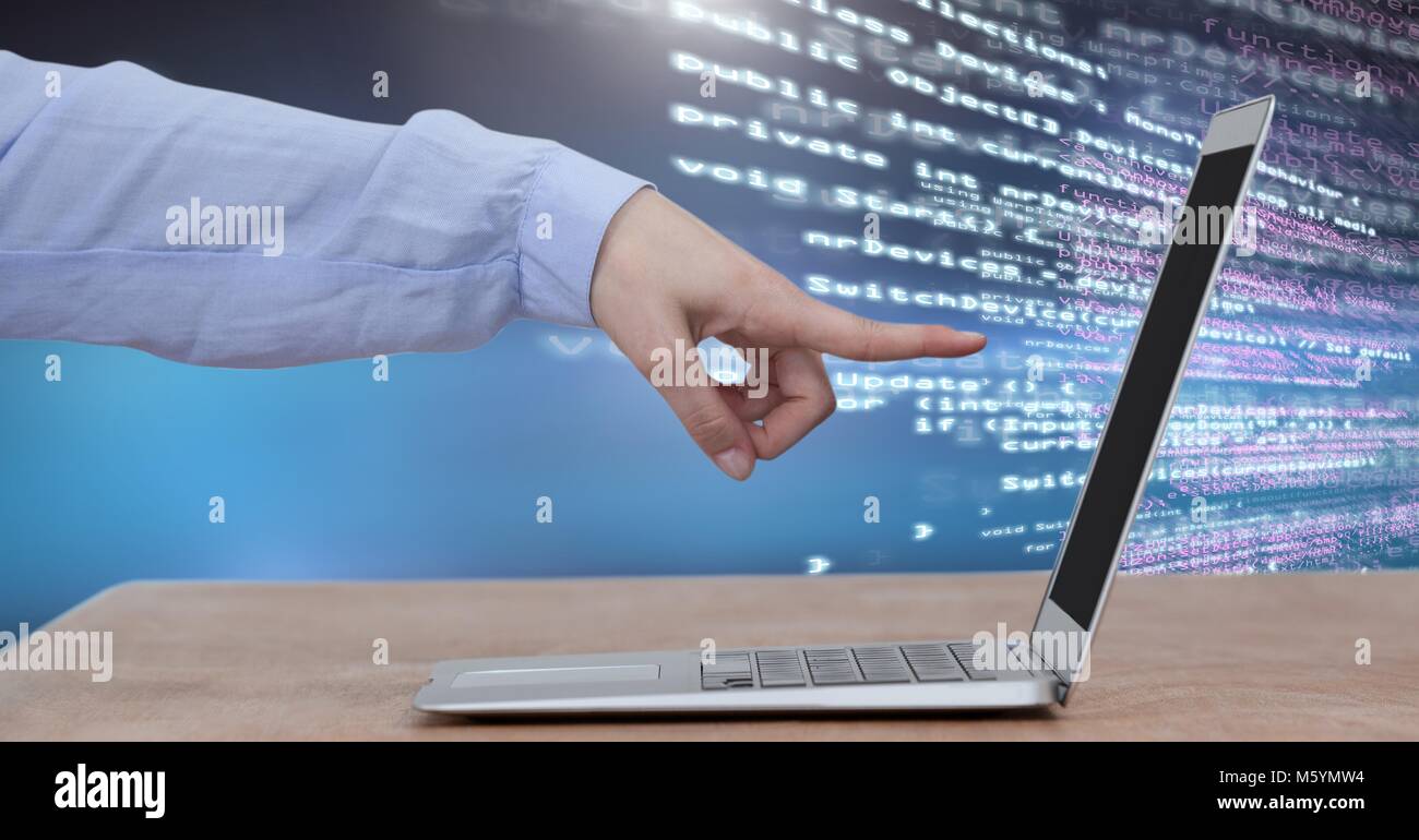 Hand pointing at laptop with coding text Stock Photo - Alamy