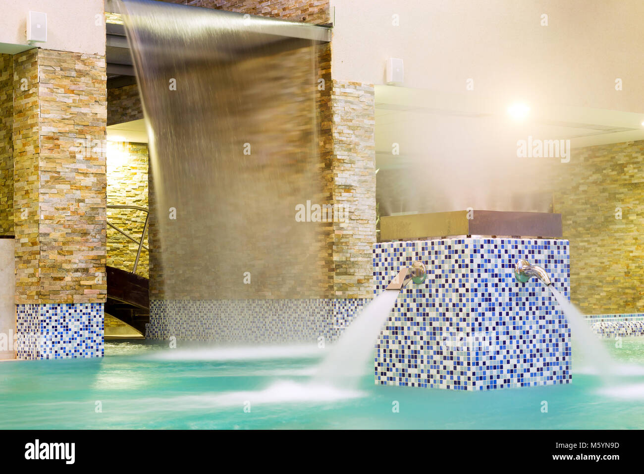 Water massage, stream of clear blue water under pressure flows into ...