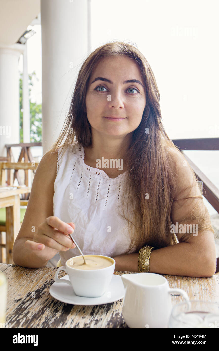 A woman is drinking cappuccino Stock Photo - Alamy