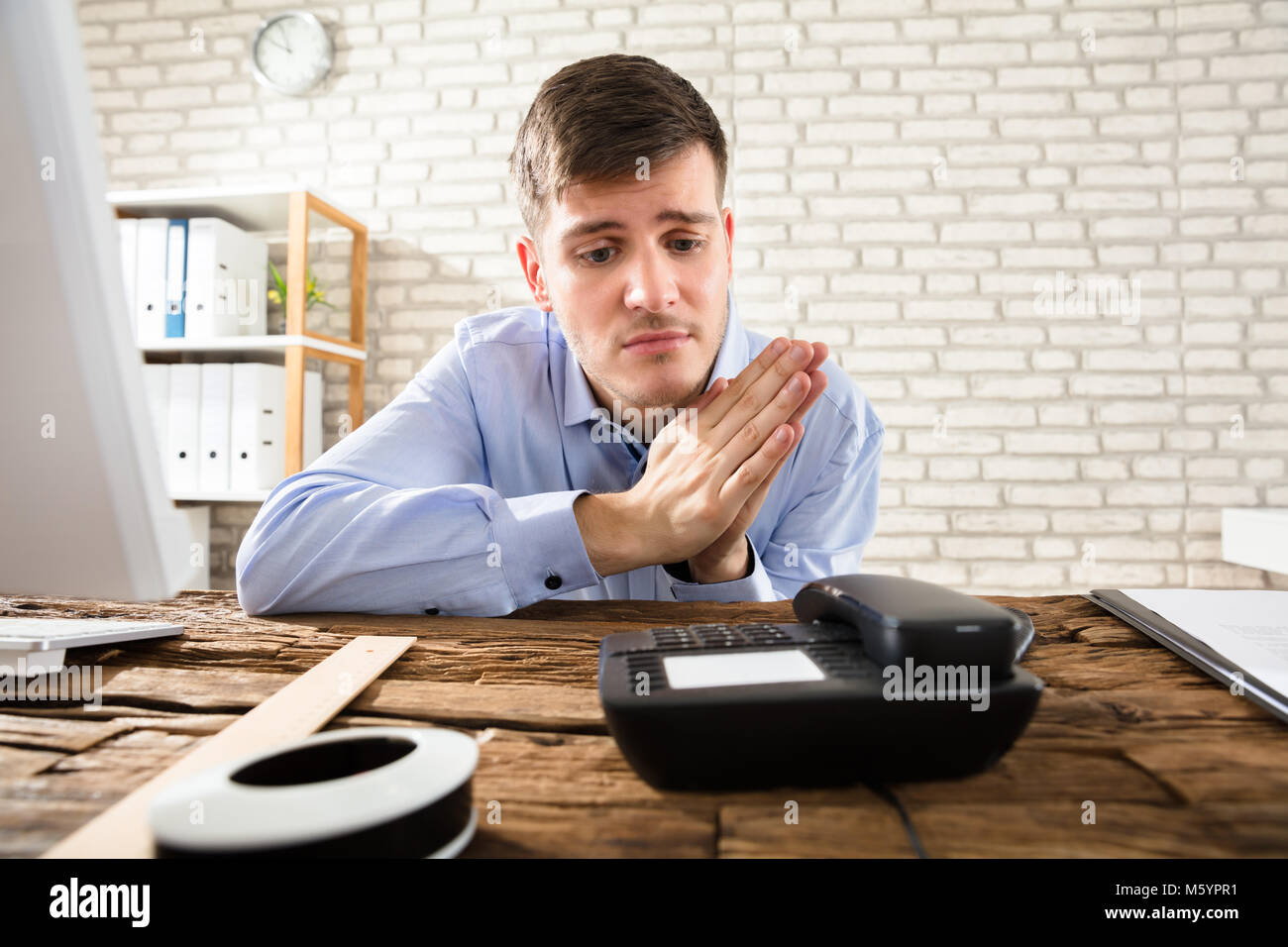 Portrait Of A Young Businessman Waiting For Call On Telephone On Wooden ...