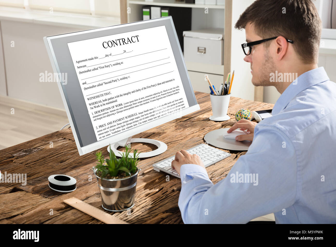 Close-up Of A Young Businessman Looking At Contract On Computer Screen ...