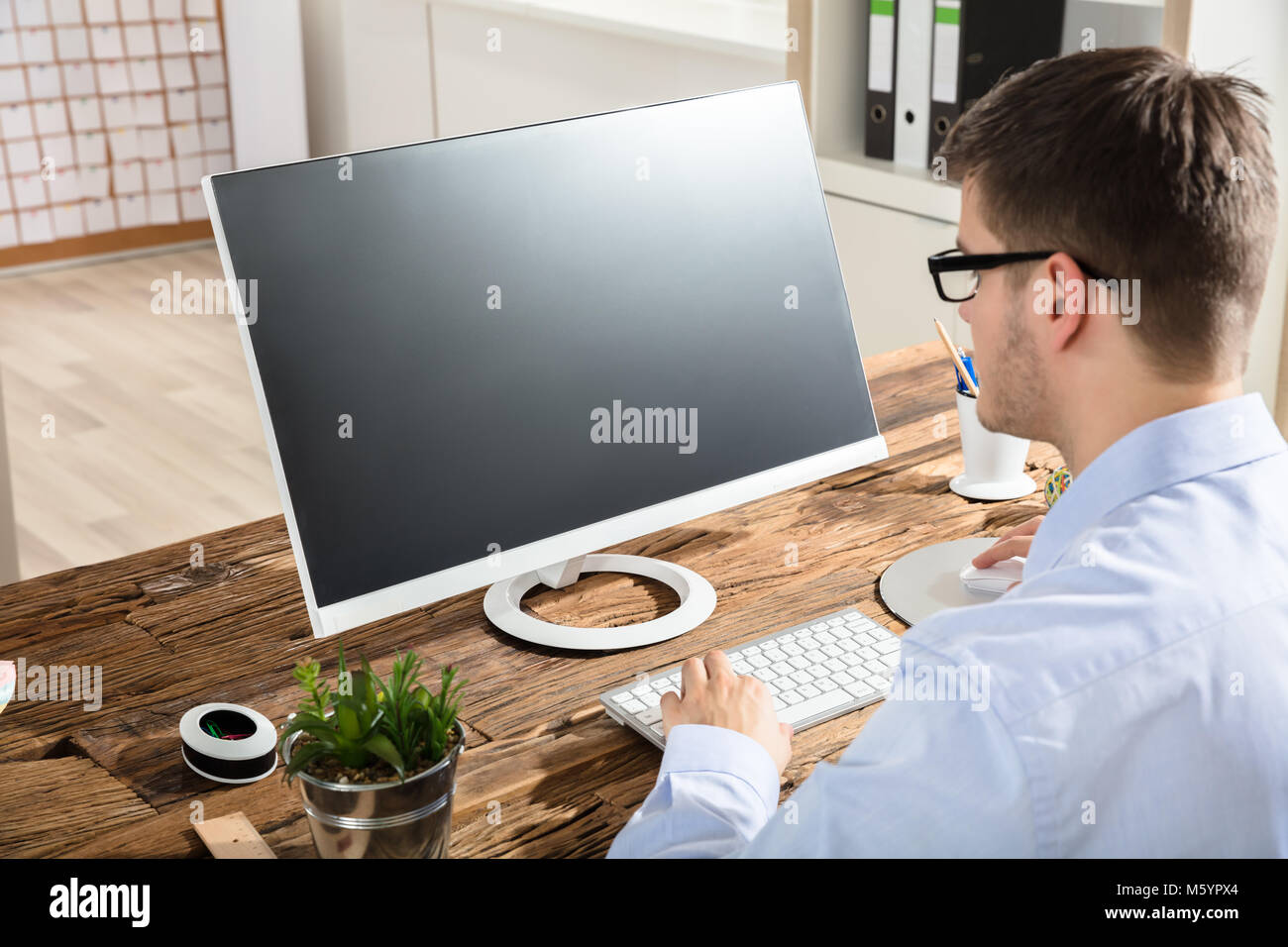 Businessman Using Computer With Black Screen In Office Stock Photo - Alamy