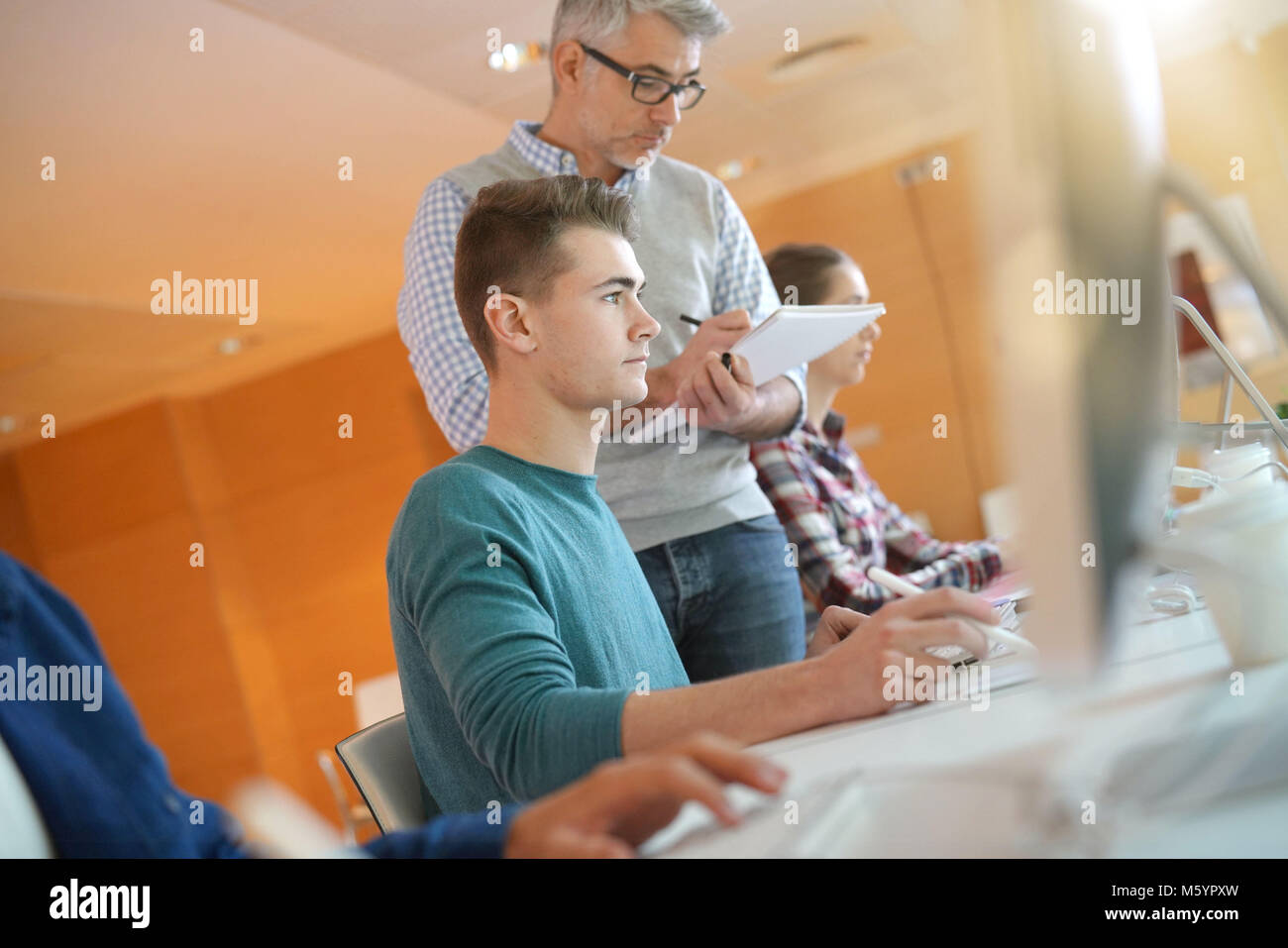 Group of students in computing class with teacher Stock Photo - Alamy