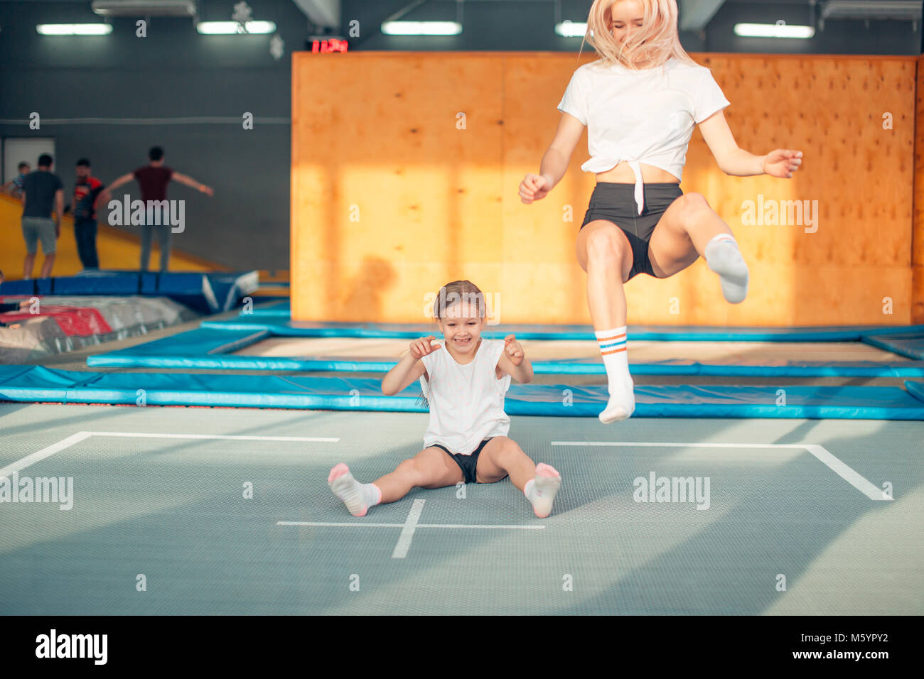 mother and daughter jumping on trampoline and doing split Stock Photo ...
