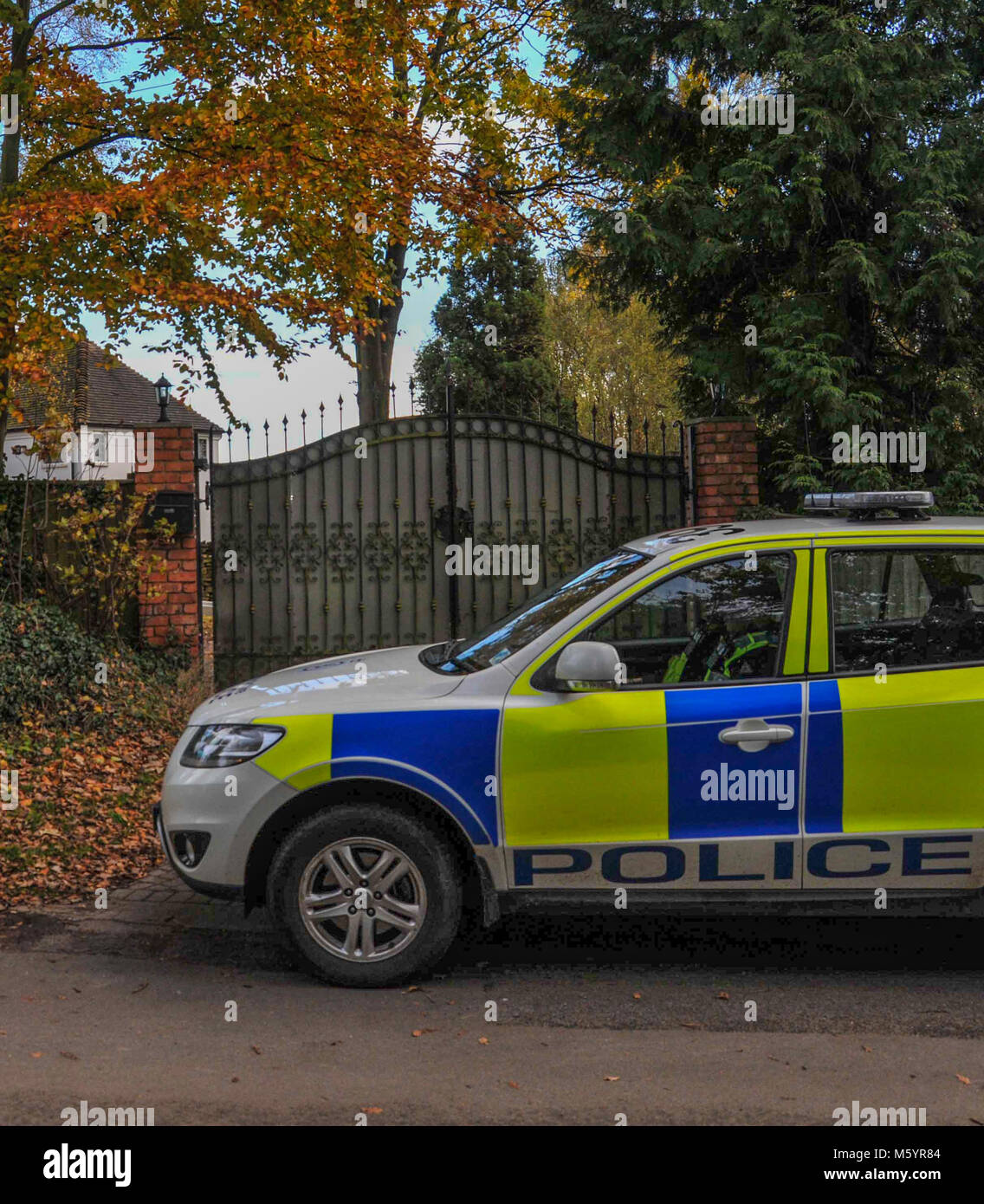 Policeman standing on guard outside a house in uniform on a cold ...
