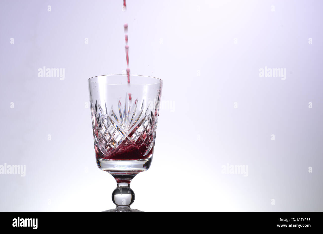 ornate Red wine Glass with wine poured into it Stock Photo - Alamy