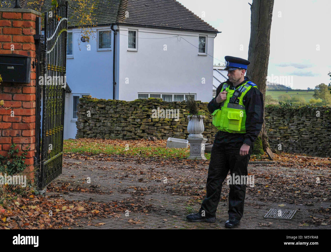 Policeman standing on guard outside a house in uniform on a cold ...