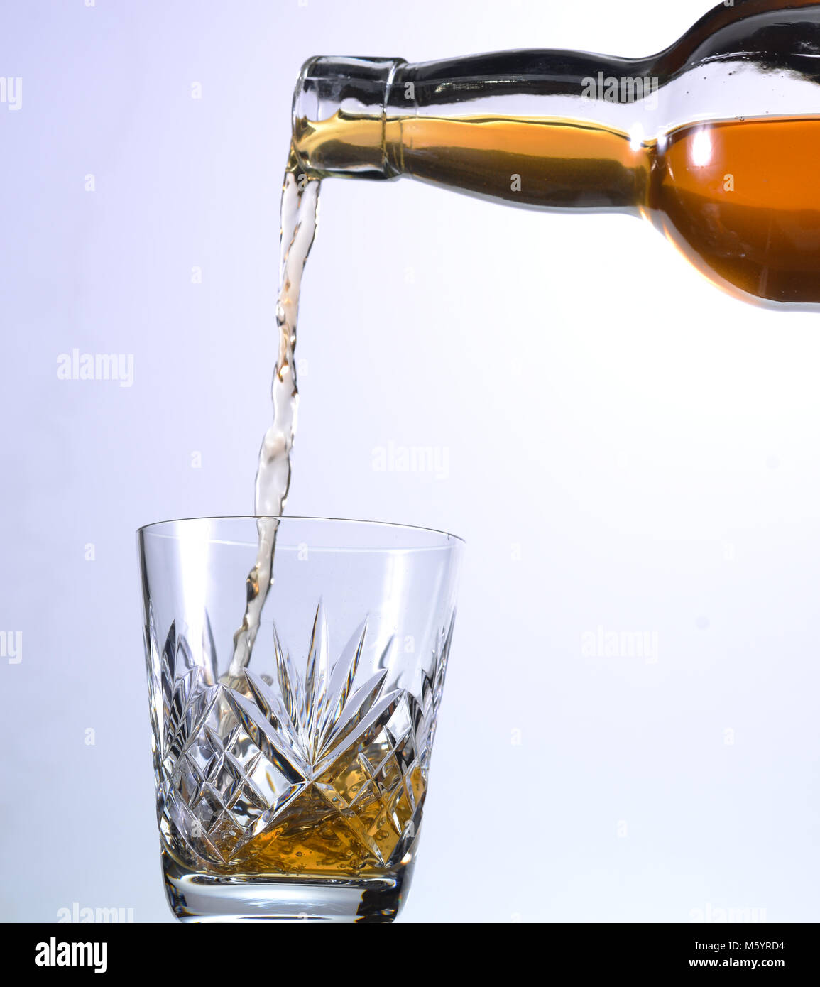 Whiskey being poured into ornate glass with white background Stock ...