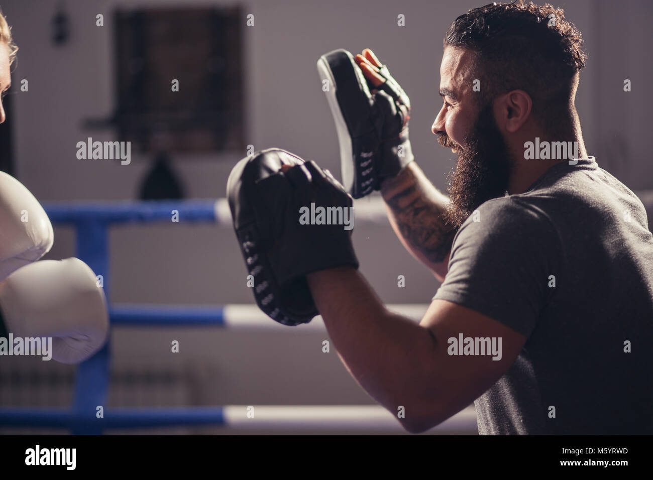 Sporty muscular young man and woman boxing together isolated on black ...