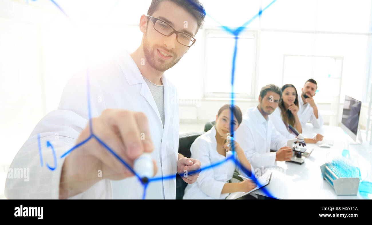 from behind the glass.scientist writes a marker on a glass Board Stock ...