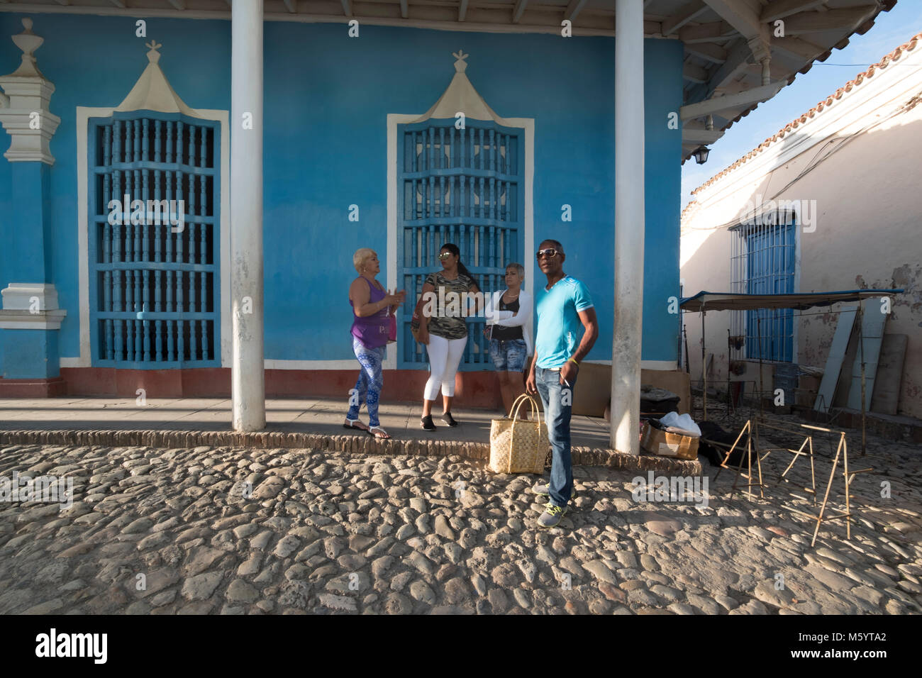 Residents in front of their typical Cuban house with wooden barred ...