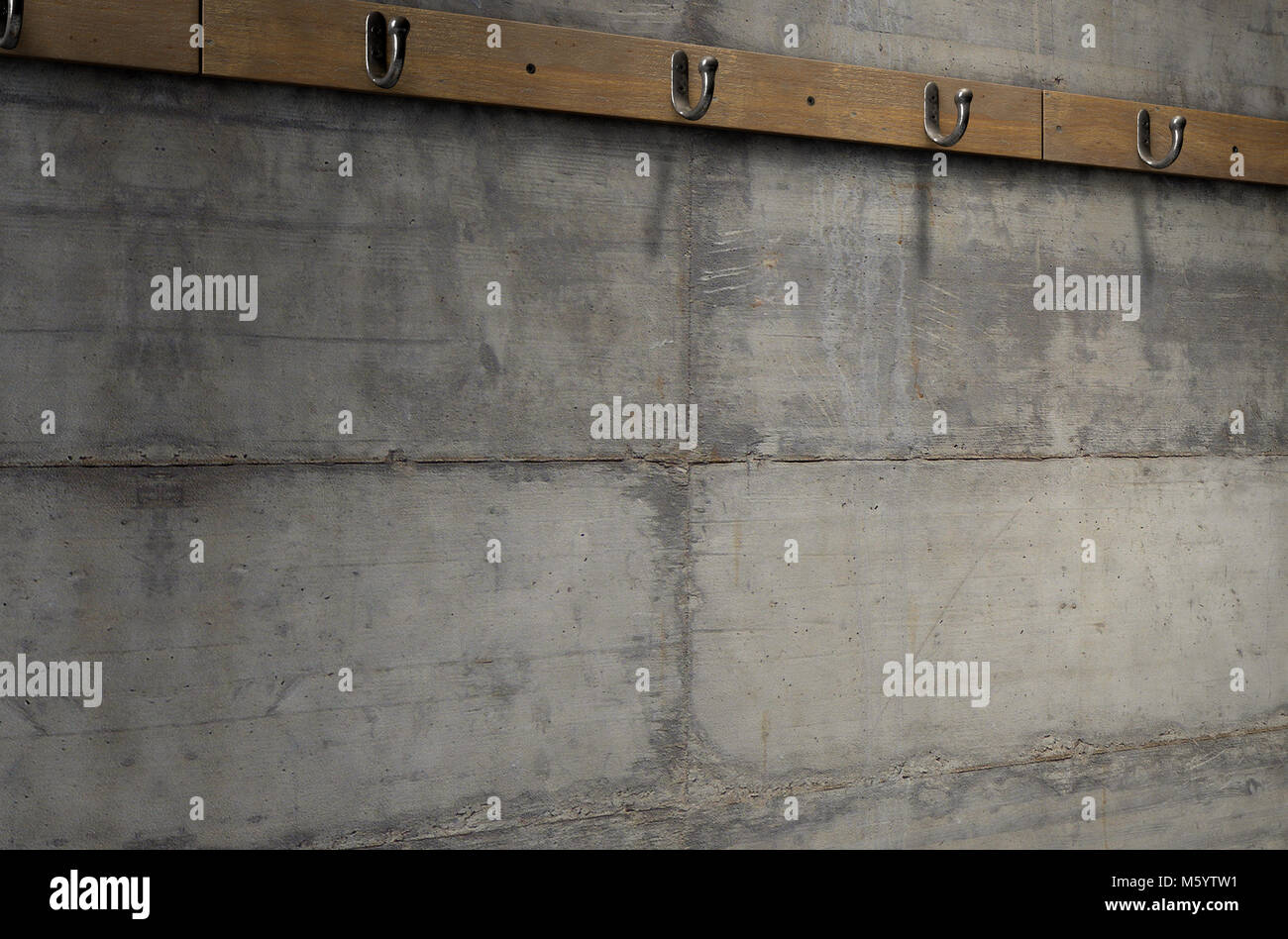 An empty clothes hanging rack above an empty wooden bench against a ...