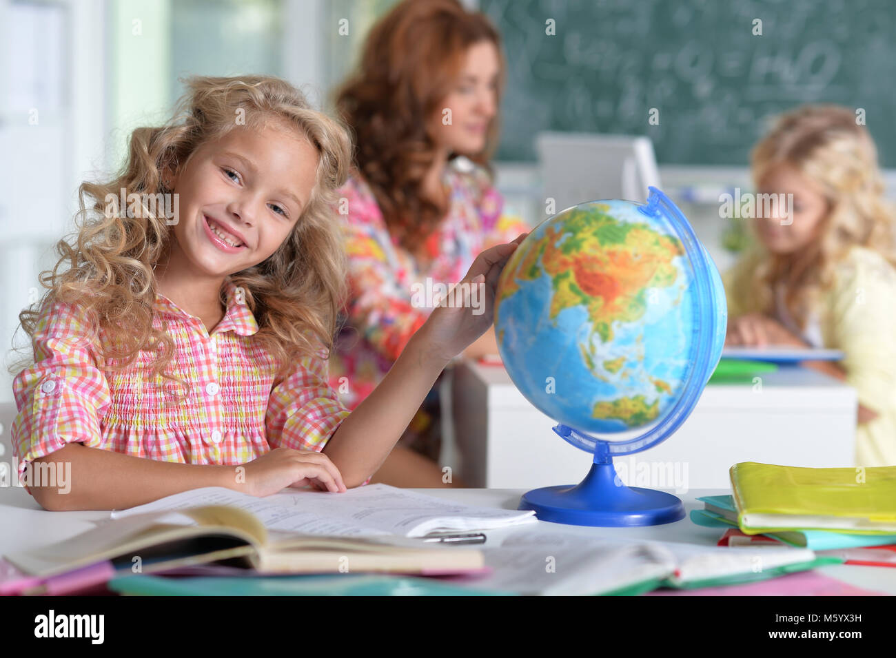 teacher with two girls at lesson Stock Photo - Alamy