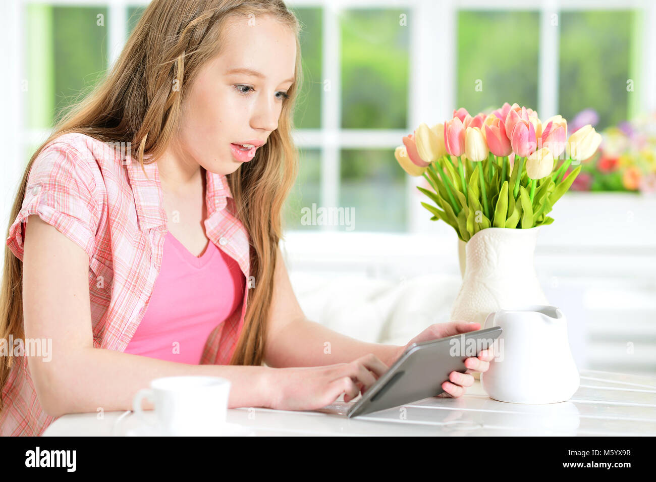 Teen girl using tablet Stock Photo - Alamy