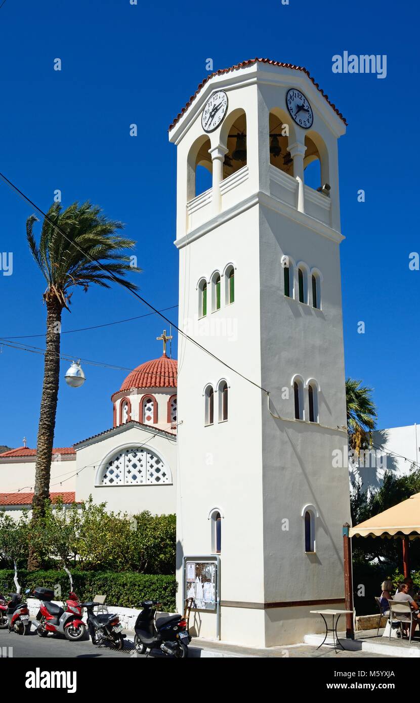 Clock tower with a Greek church to the rear in the town centre, Elounda ...