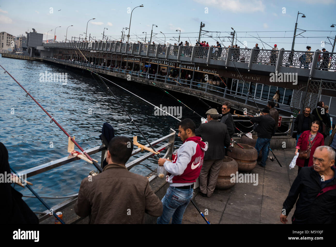 Galata Bridge lined with fishermen and fish restaurants Stock Photo - Alamy